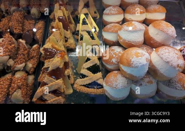 Assorted Italian pastries in bakery display including cream-filled buns ...