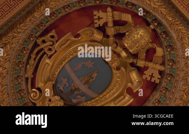 Close detail of gold papal coat of arms set within ornate coffered ...