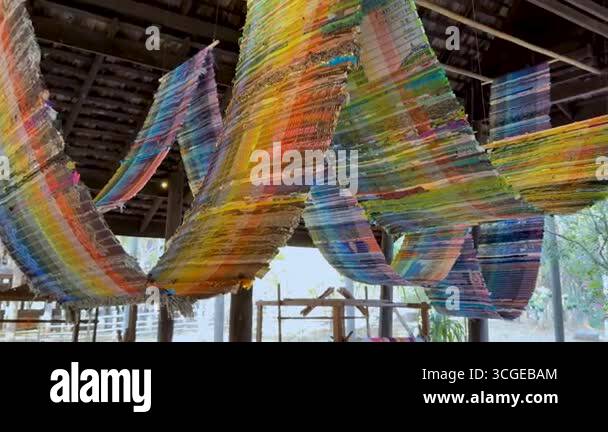 Vibrant fabric weaving under a wooden structure Stock Video Footage - Alamy