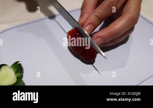 Slicing a strawberry on a cutting board Stock Video Footage - Alamy