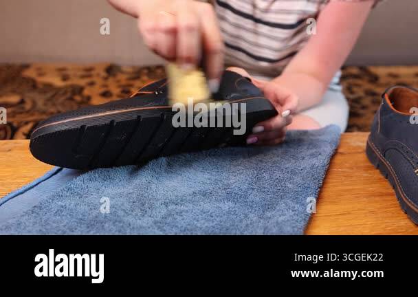Person cleaning, polishing, and caring for leather shoes using brushes ...