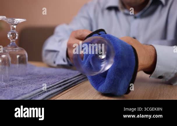 Man polishing wine glass with cloth after washing, removing water drops ...