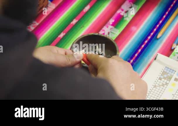 Close-up of hands sharpening a color pencil using a knife, with a ...