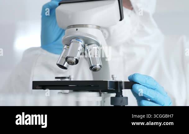 Scientific researcher wearing blue protective gloves fine tuning ...