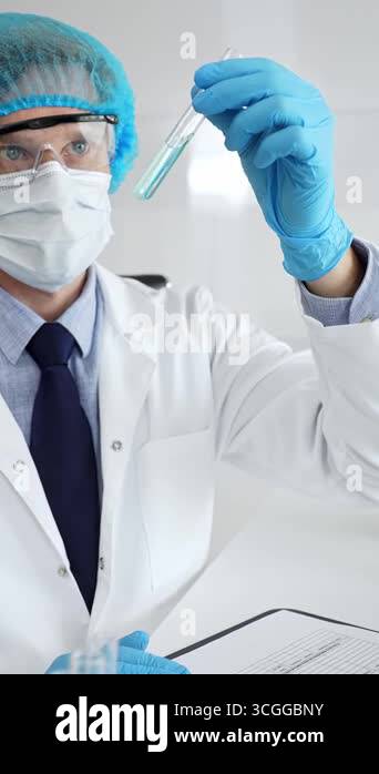 Scientist in a face mask and safety glasses, wearing a lab coat and ...