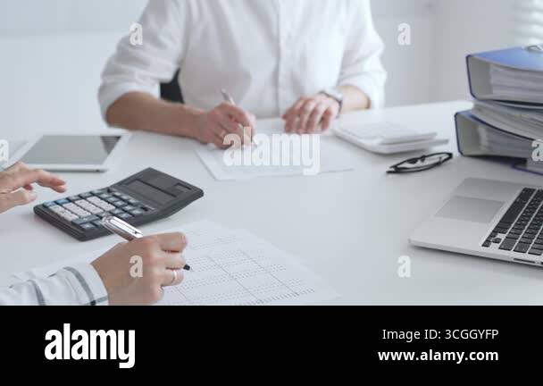 Financial professionals reviewing spreadsheets, working together at modern workspace with ...