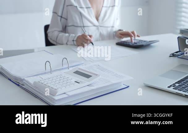 Close up of a calculator on financial documents, with an accountant ...