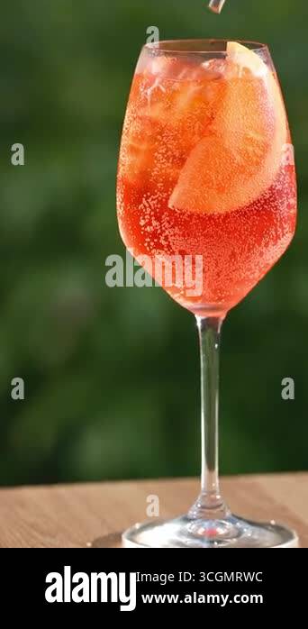 fresh refreshing aperol spritz cocktail in a glass with straw against a ...