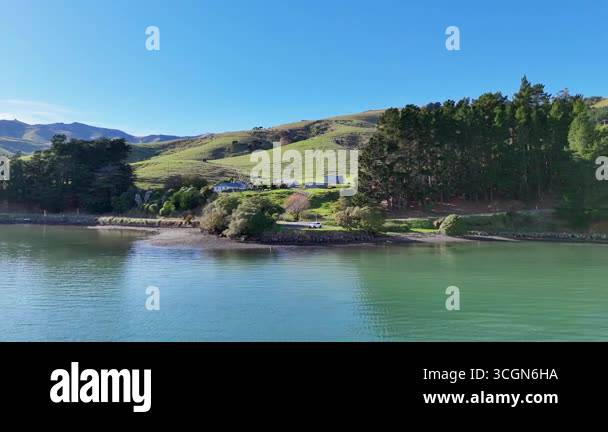 Aerial footage captures Akaroa's serene lakeside with lush greenery ...