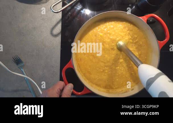 Stockholm, Sweden a cook uses a hand blender to mix a corn soup in a ...