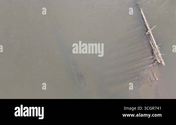 Aerial macro video of old submerged wooden posts creating linear ...