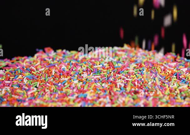 Vibrant sprinkles cascade onto a pile Stock Video Footage - Alamy
