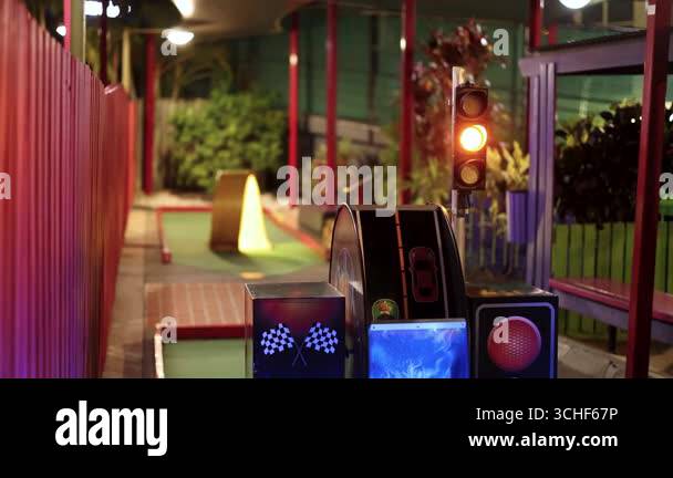 A vibrant miniature golf course features animated traffic lights and ...