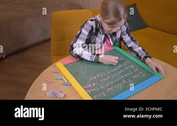 A primary school student carefully works out her writing skills ...