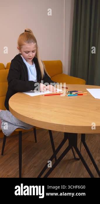 Concentrated elementary school student draws a picture with colored ...