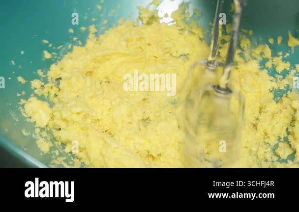 Stirring the batter in a bowl using a hand mixer during the cake-making ...