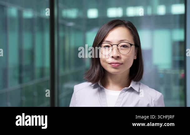 Portrait of serious asian businesswoman standing at workplace in modern ...