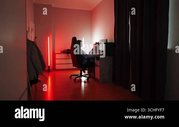 Gaming session takes place in a dimly lit room with vibrant lights and ...