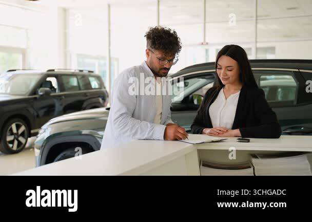 Professional car salesperson guiding customer through final purchase ...