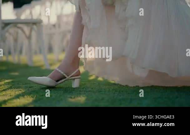 Close-up view of bride and groom legs walking together in garden during ...