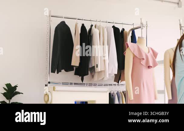 Two young fashion designers collaborate in bright studio. Tailoring ...