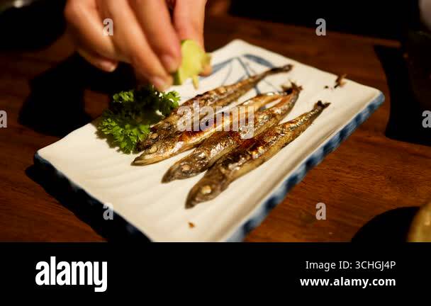 Person squeezing lemon on fried fish Stock Video Footage - Alamy