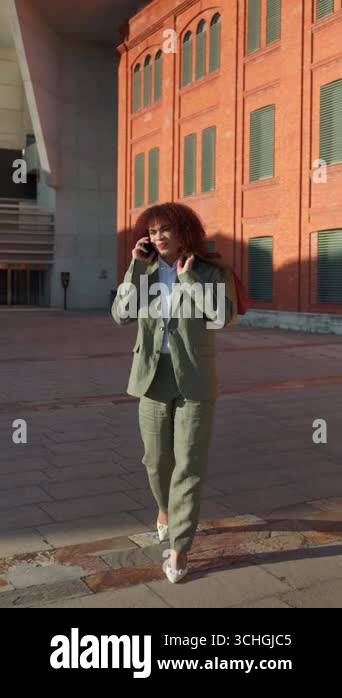 Professional trans woman engaged in a business phone call outdoors ...
