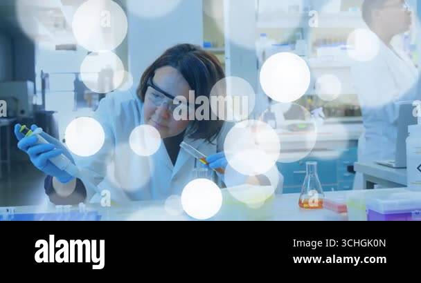 Researcher reaching rack aspirating dispensing blue solution and orange ...