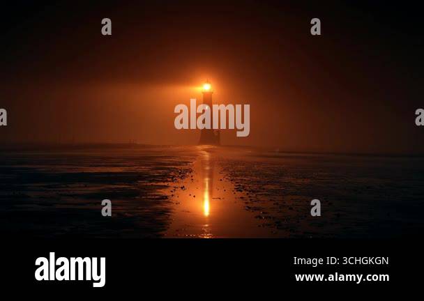 A distant lighthouse glows warmly in the mist, casting a serene ...