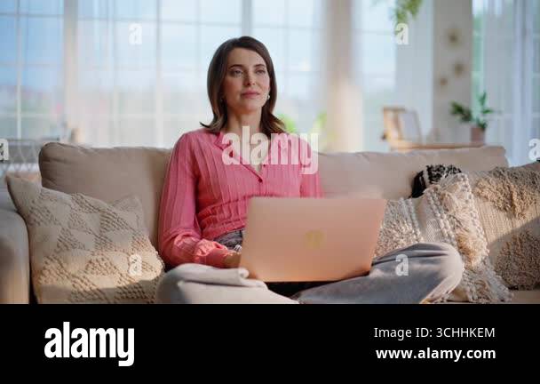 Distant manager browsing laptop developing e-commerce project at home. Thoughtful woman thinking ...