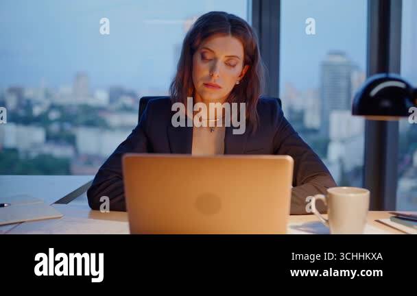 Tired businesswoman watching laptop report in evening office closeup ...
