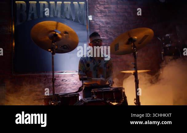 Talented drummer performing on stage sitting in smoke. Professional ...