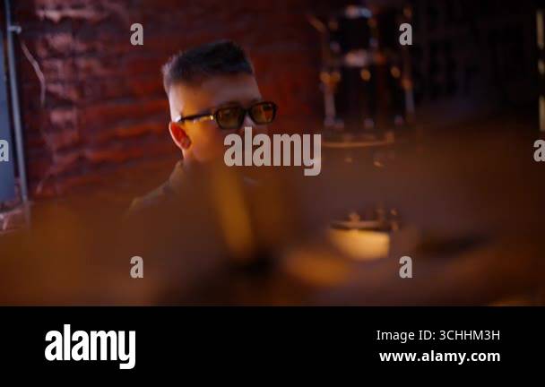 Young drummer making beat with rock band at dark nightclub stage ...