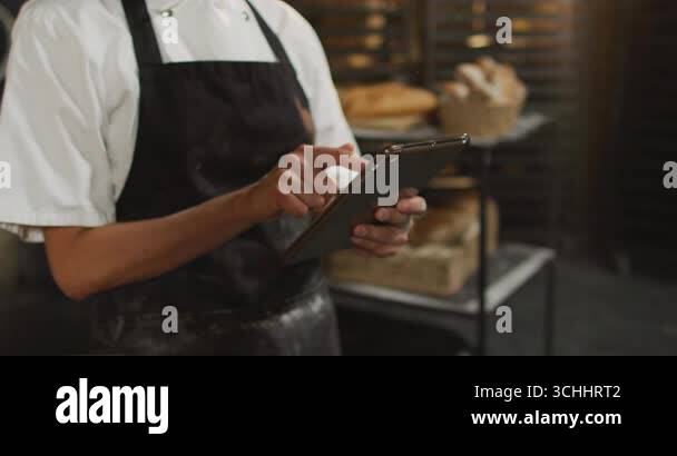 Animation of hands of asian female baker using tablet. working at ...
