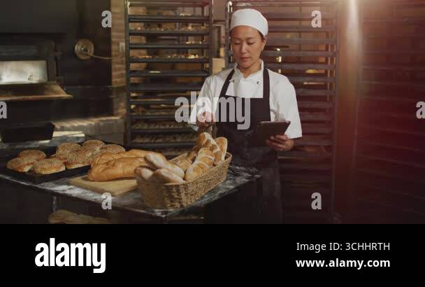 Animation of asina female worker using tablet and counting breads ...