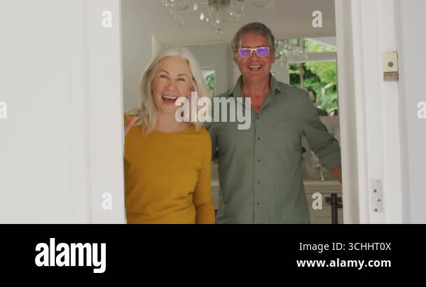 Animation of happy caucasian senior couple opening doors and welcoming ...