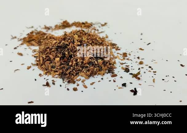 A pile of dried tobacco on a white background. Tobacco is a plant whose ...