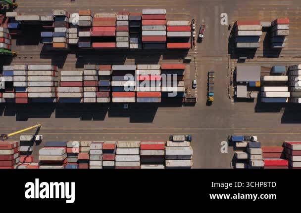 Colored cargo containers and trucks in a sea port. Aerial top view from ...