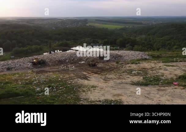 Rural landscape with bulldozers on a garbage pile. Ecological problem ...
