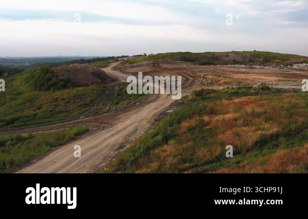 Tractor on a countryside rural garbage dump field. Ecological ...