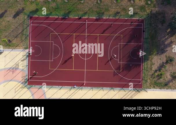 Aerial view of boys play basketball on the red court. Rapid speed ...