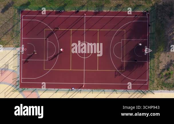Aerial view of boys play basketball on the red court. Fast speed motion ...