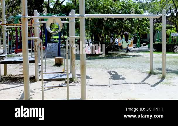 Kids enjoying swings and slide in park Stock Video Footage - Alamy