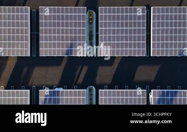 Drone footage shows a detailed aerial top view of a solar panel carport ...