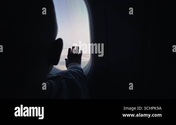 Childs hand touches airplane skylight, expressing curiosity and ...