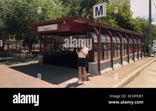 Female traveler at a transit station, engaged with a digital map on her ...