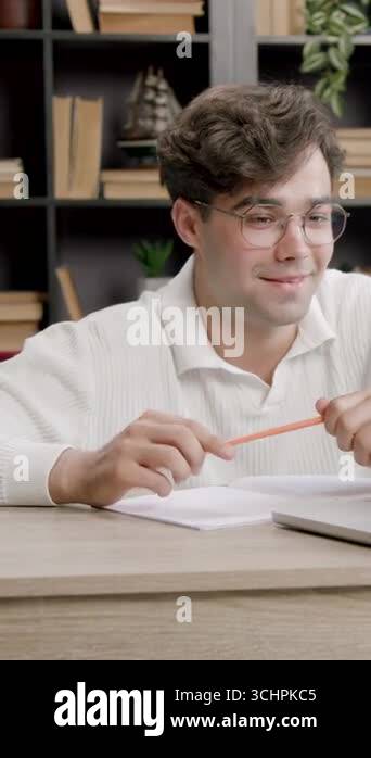 Man smiles and leans on back of chair after speaking during online ...