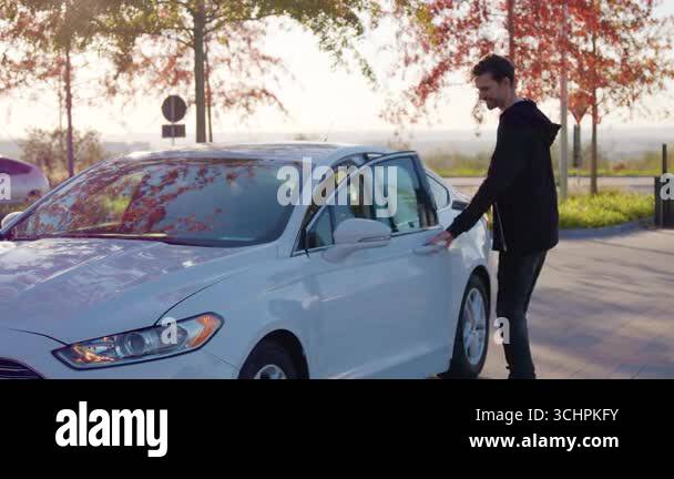 Person reaching for the door of a white car in a picturesque setting ...