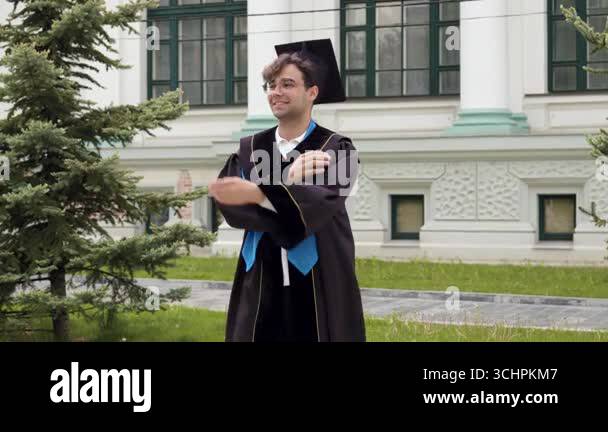 Proud graduating student stands with his hands on his chest wearing a ...