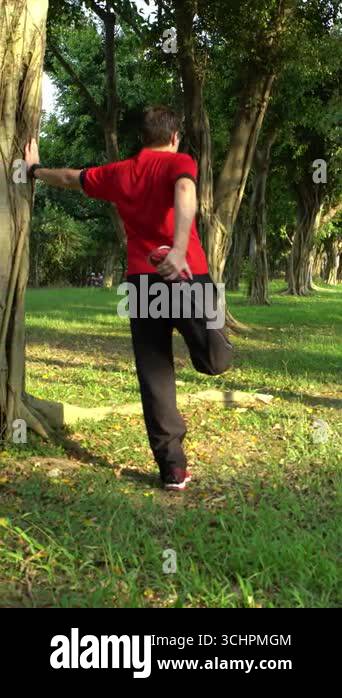 4K Caucasian man stretching before run on path of Daan Park Taipe city ...